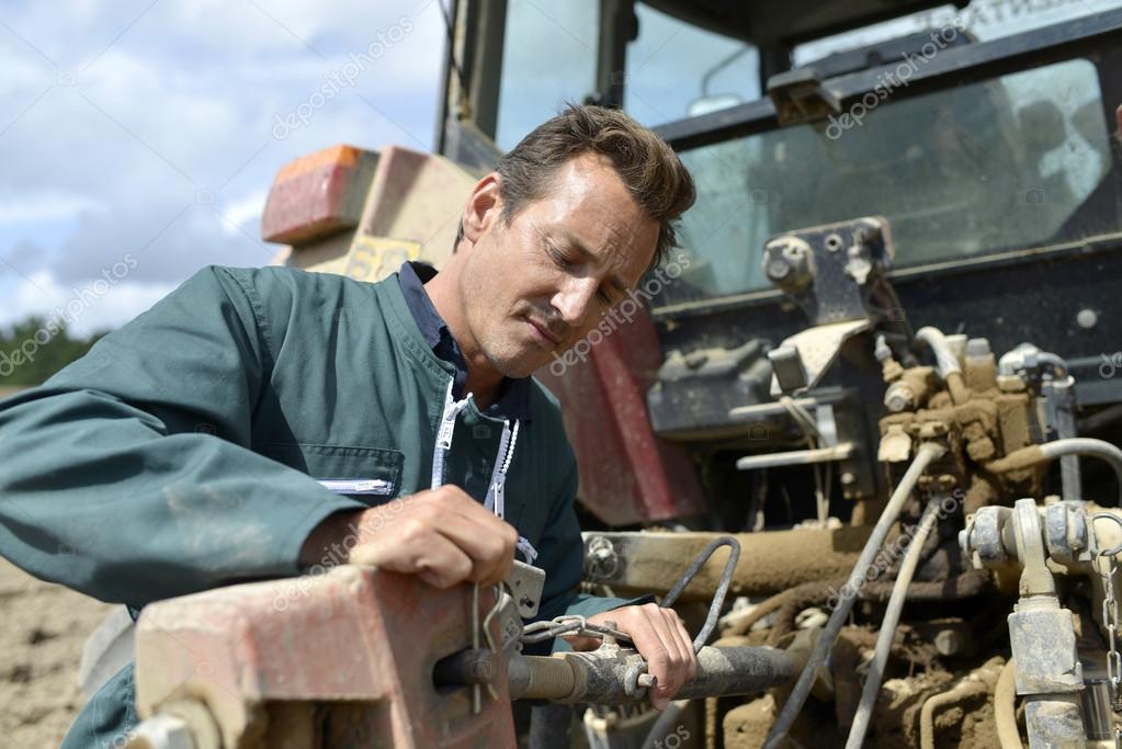 Farmer working on tractor — Stock Photo © Goodluz #47786865