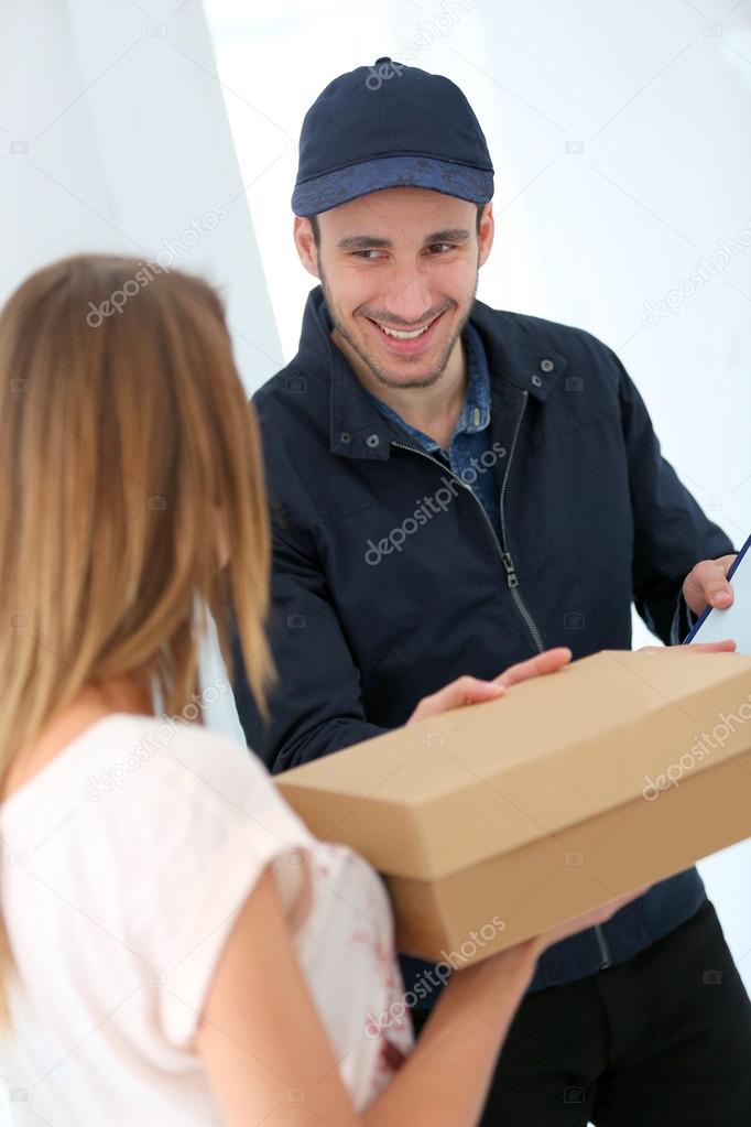Delivery man giving card box Stock Photo by ©Goodluz 47820009
