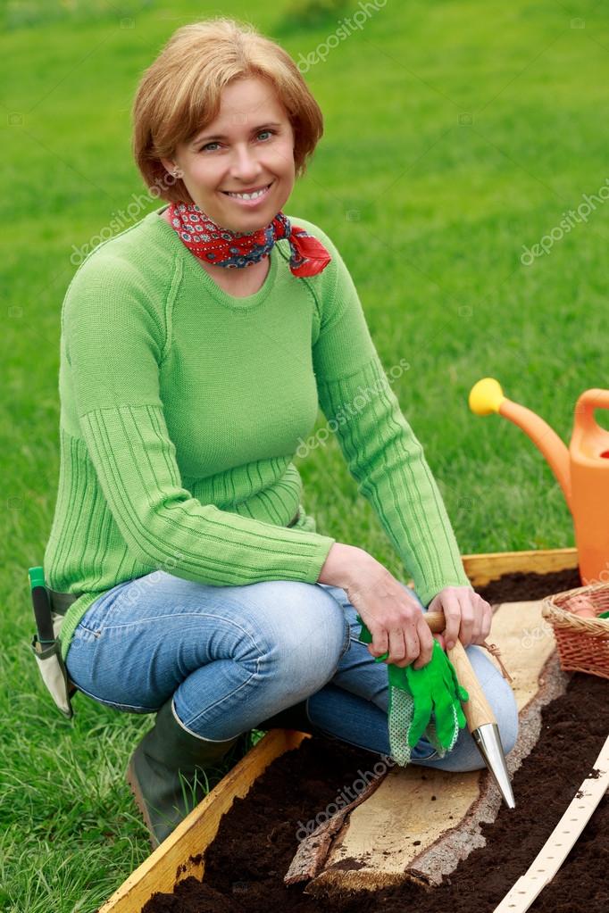 Gardening, sowing - woman sowing sugar peas into the soil Stock Photo ...