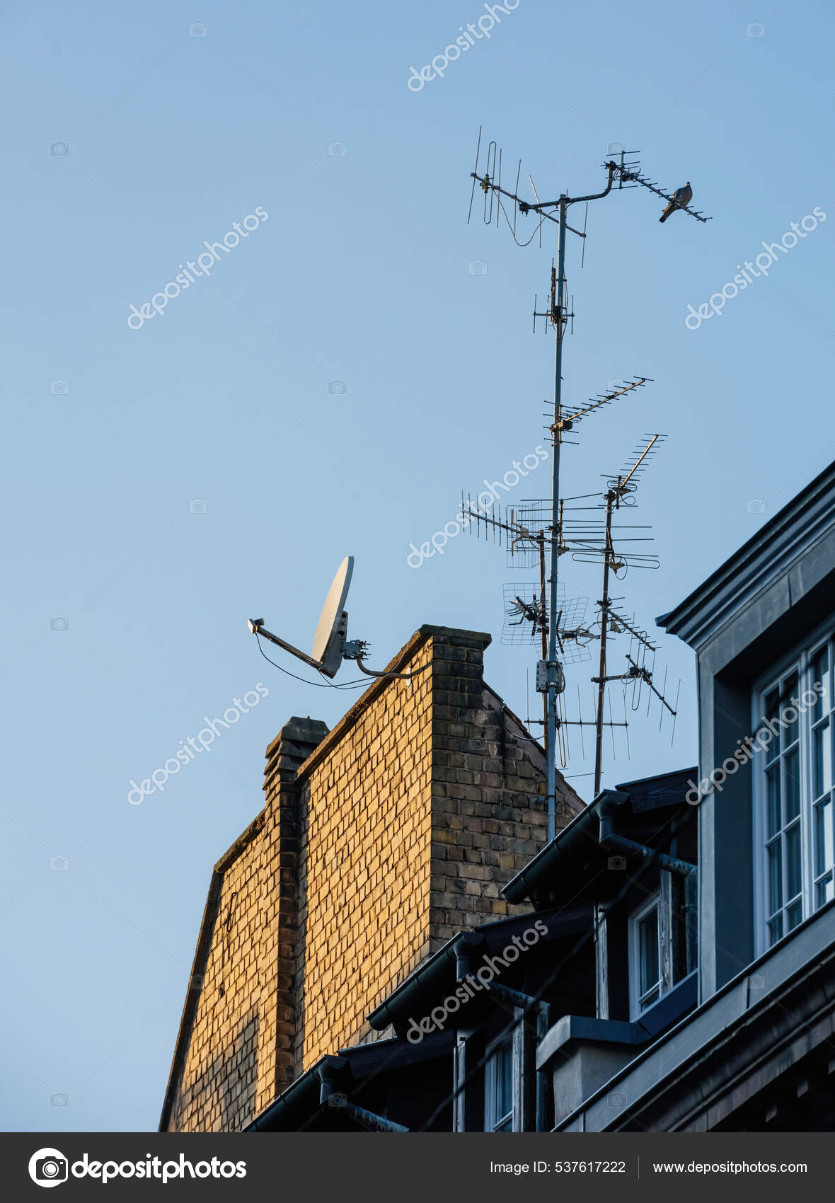 Large satellite communication dish on the rooftop of apartment building ...