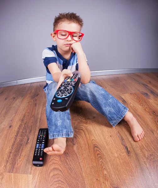 Little boy changing channels on TV using remote control, isolated on ...