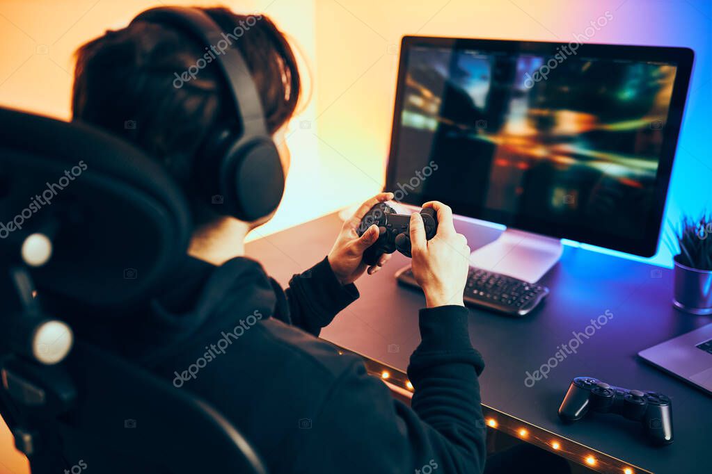 Hombre jugando a videojuegos en casa. Gamer sosteniendo mandos sentados ...