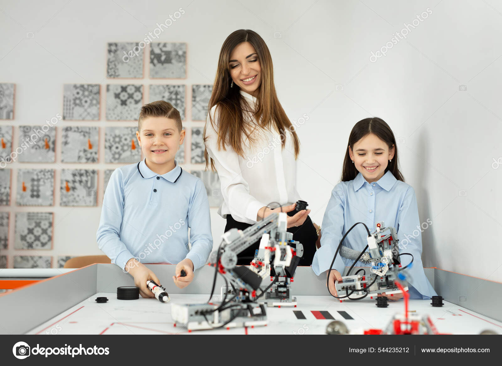 Young beautiful mother with her son and daughter pose at the school of ...