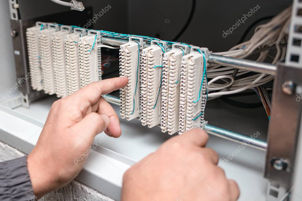 Un electricista comprueba los terminales de los equipos de comunicación ...