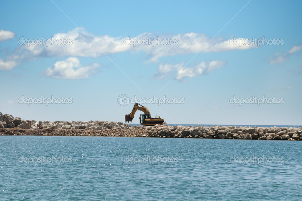 Building a dike. Excavator put stones Stock Photo by ©deyangeorgiev2 ...