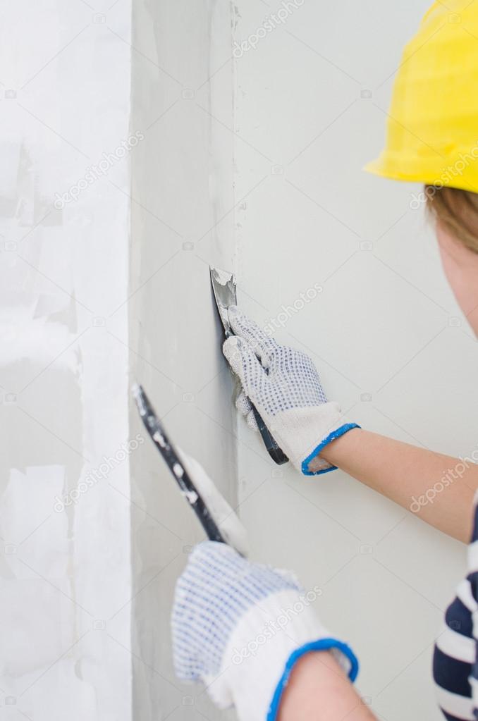 Female plasterer repairs wall with spackling paste Stock Photo by ...