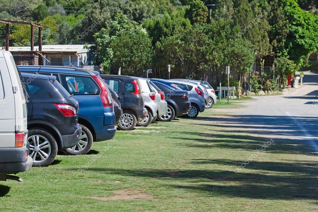Cars parked in a parking lot on the grass. — Stock Photo © dmitrimaruta ...