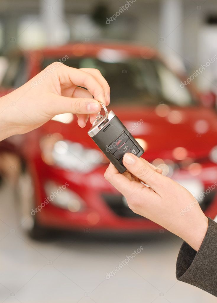 Female hand getting modern car key on a red car background — Stock ...
