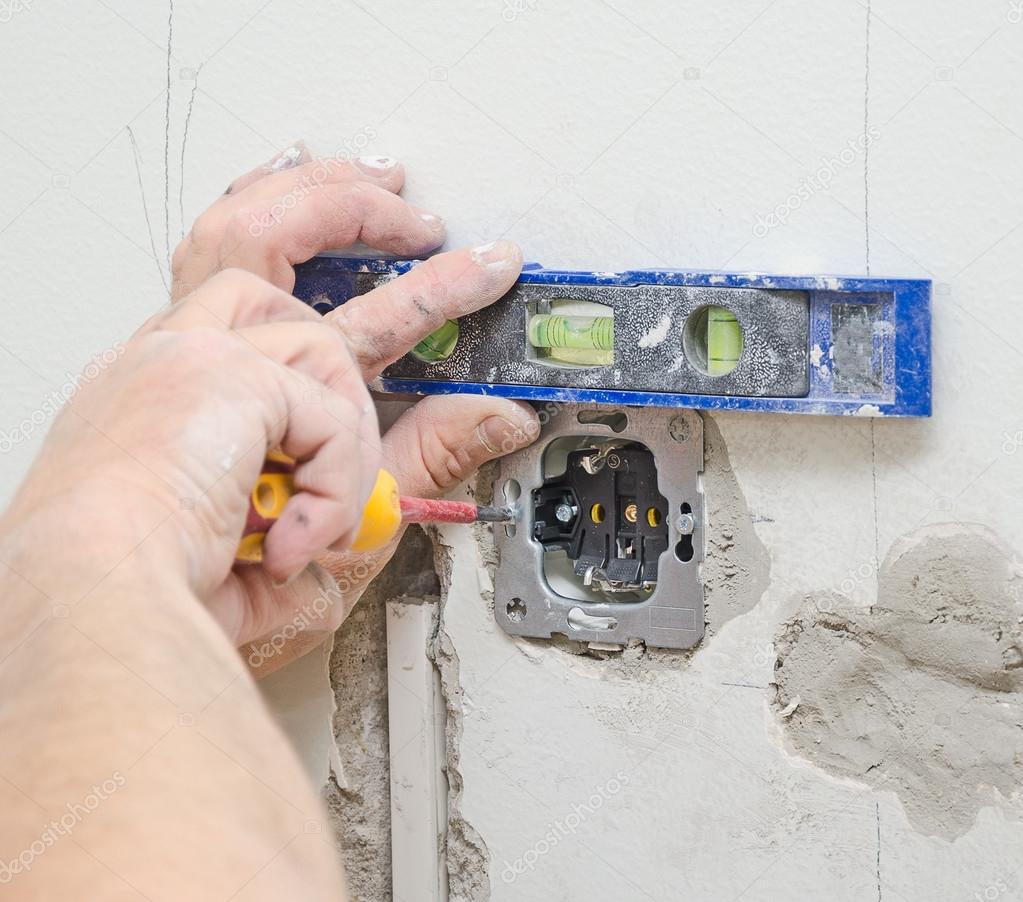 Certified electrician installing socket for light switch. — Stock Photo ...