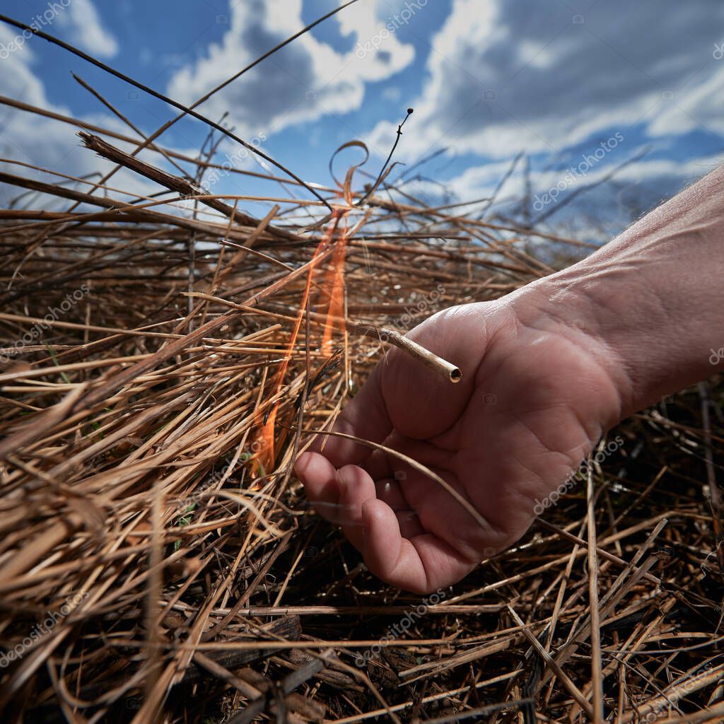 Persona irreconocible quemando hierba seca en el campo 2024