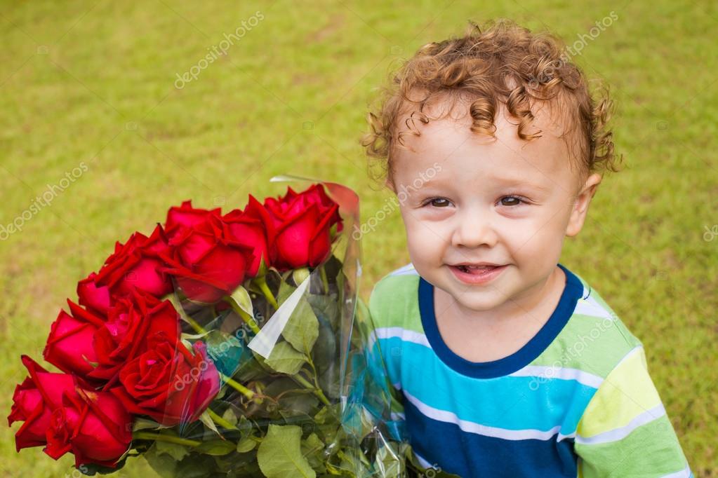 Happy child with a bouquet of red roses — Stock Photo © altanaka #12698082