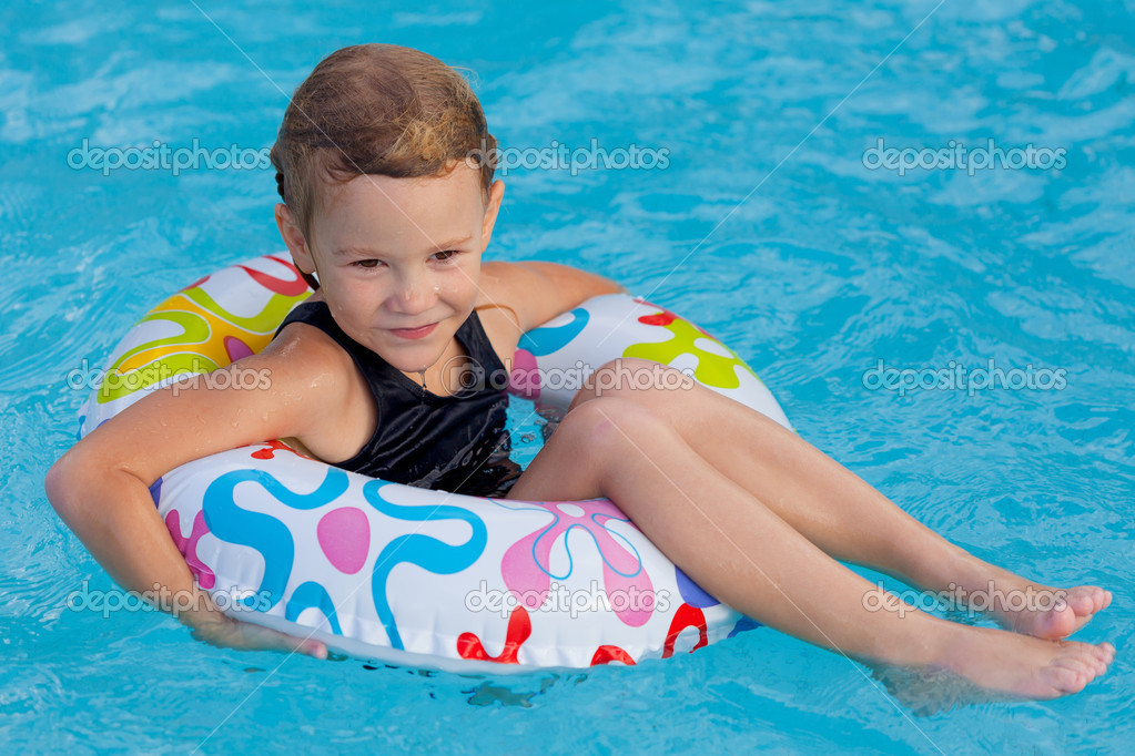 Little girl in the pool with rubber ring Stock Photo by ©altanaka 30891125