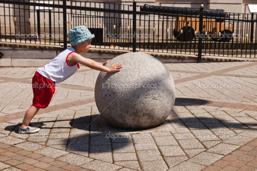 Child pushing great heavy ball — Stock Photo © andyphotoland #12033078