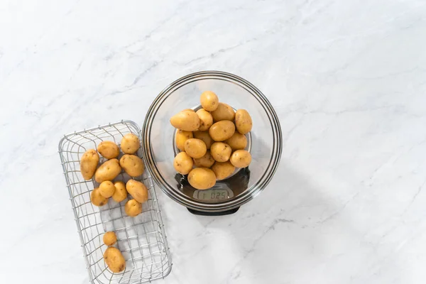 Flat lay. Pressure Cooker Baked Potatoes. Measuring raw potatoes in a ...