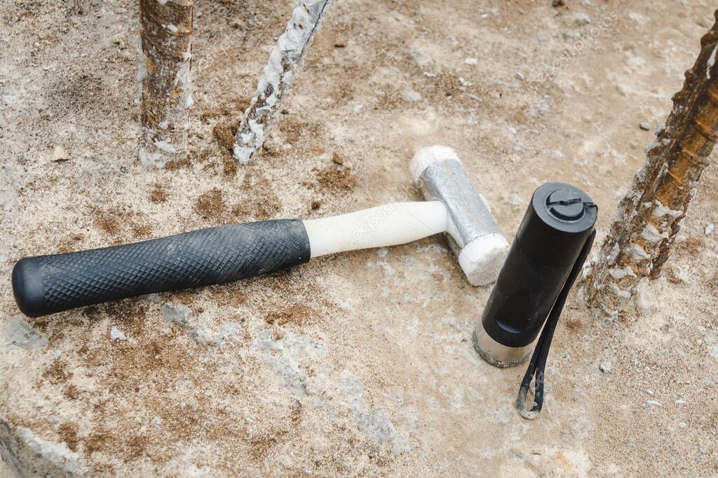 Seismic test on concrete pile. Engineer using the PIT Hand-Held Hammer ...