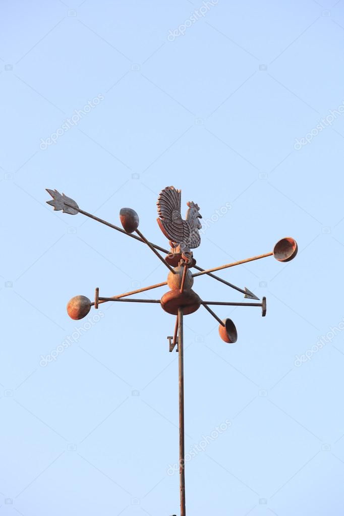 Weather Vane compass over house roof against blue sky background Stock ...