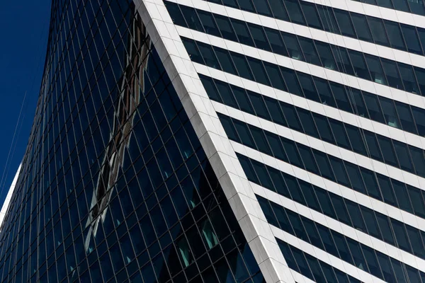 high-tech office building with transparent walls reflecting a bright ...