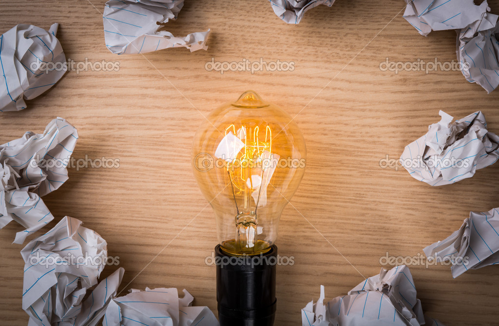 Light bulb with Crumpled paper on wood background Stock Photo by ...
