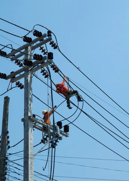 An electrical power utility worker fixes the power line — Stock Photo ...