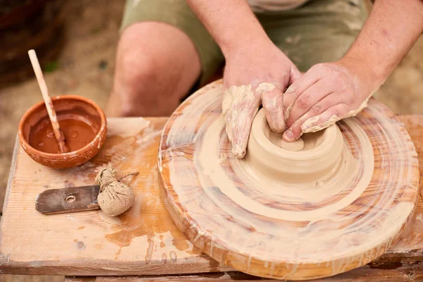 closeup male hands in work with white clay. master in light linen shirt ...