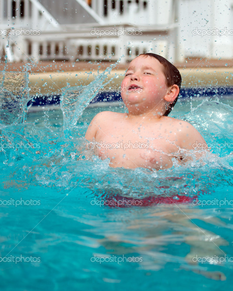 Young boy splashing into pool while swimming Stock Photo by ©RobHainer ...