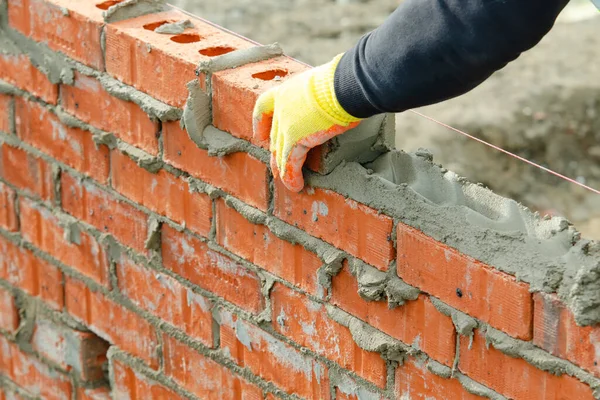 Bricklayer laying bricks on mortar on new residential house ...
