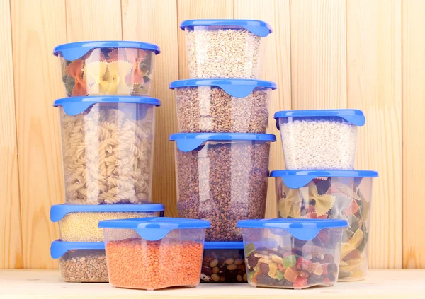 Filled plastic containers on wooden background — Stock Photo ...