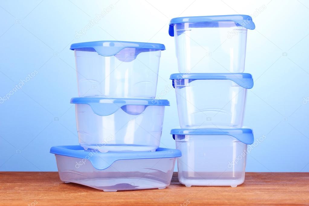 Plastic containers for food on wooden table on blue background Stock ...