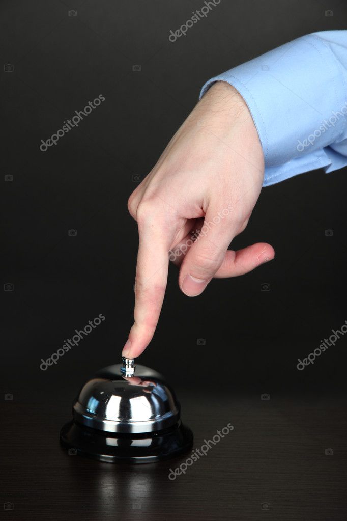 Hand ringing in service bell on wooden table on black background Stock ...