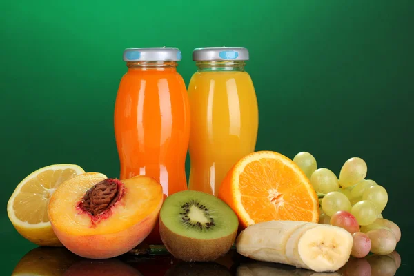 Delicious multifruit juice in a bottle and fruit next to it on yellow ...