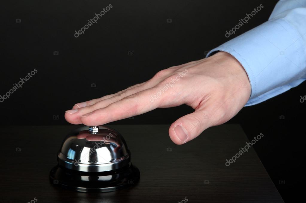 Hand ringing in service bell on wooden table on black background Stock ...