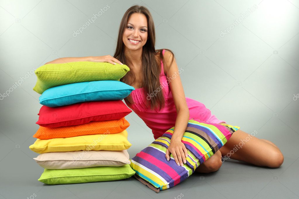 Beautiful young girl with pillows on grey background Stock Photo by ...