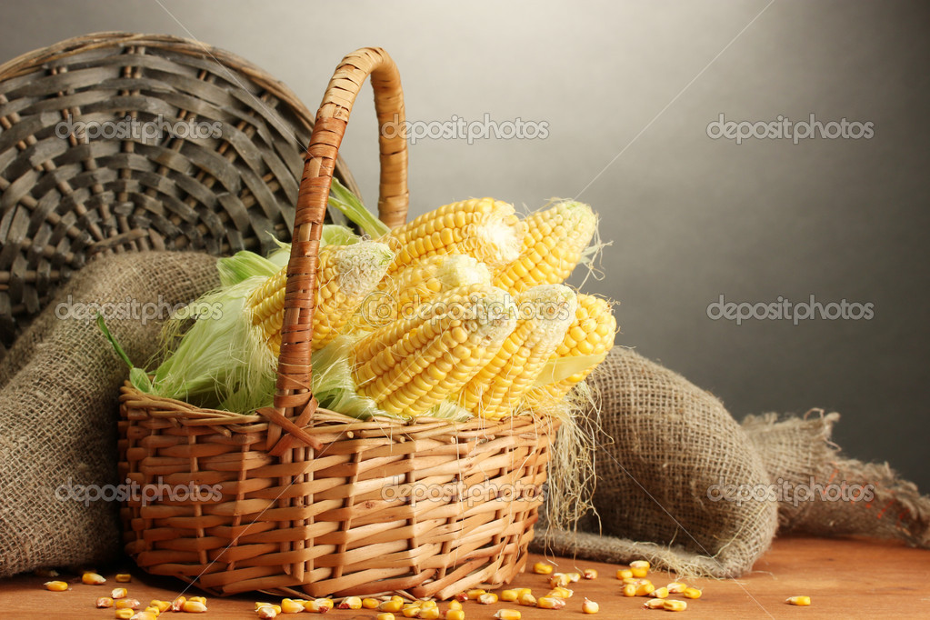 Fresh corn in basket, on wooden table, on grey background — Stock Photo ...
