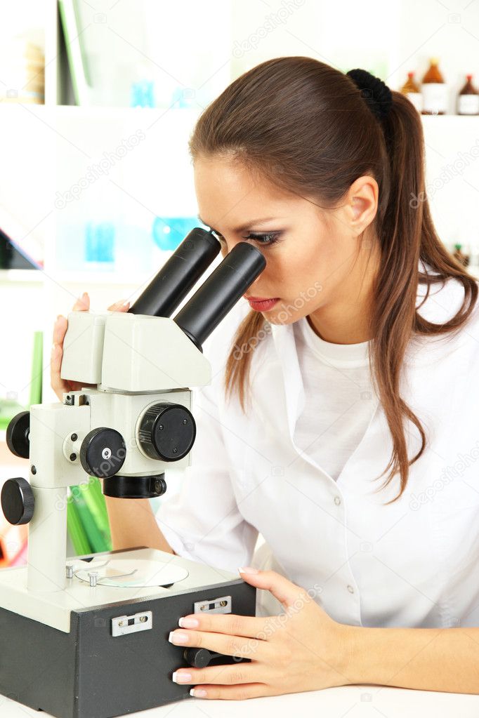 Científico joven mirando al microscopio en laboratorio: fotografía de ...