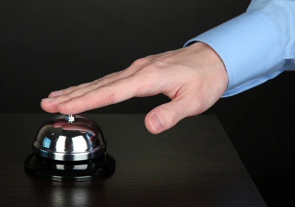 Hand ringing in service bell on wooden table on black background Stock ...