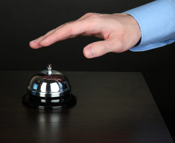 Hand ringing in service bell on wooden table on black background Stock ...