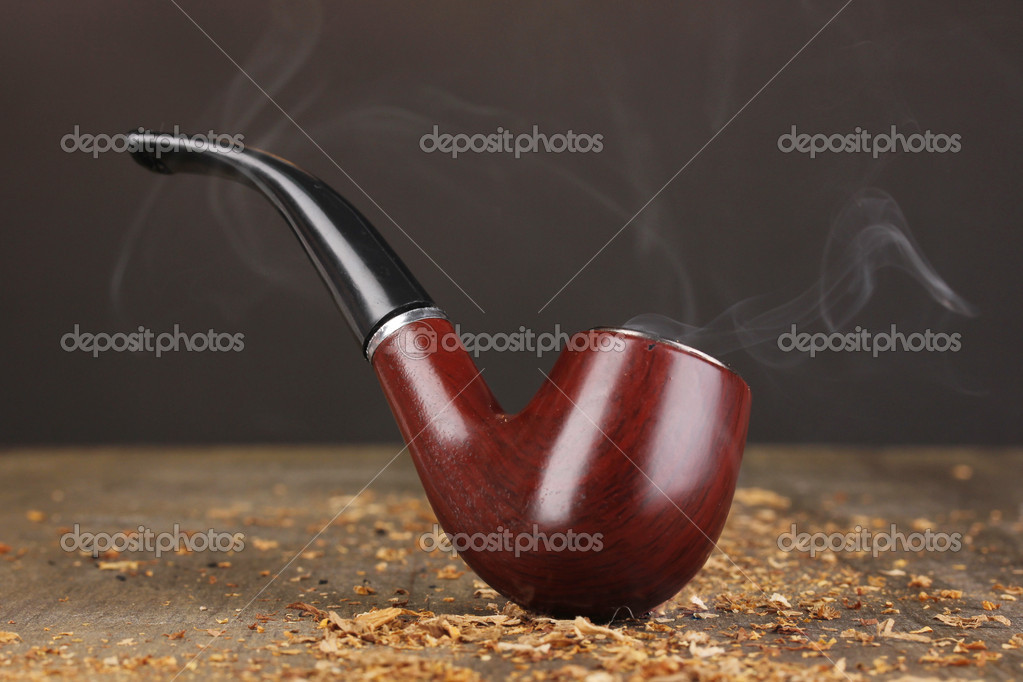 Smoking pipe and tobacco on wooden table on black background Stock ...