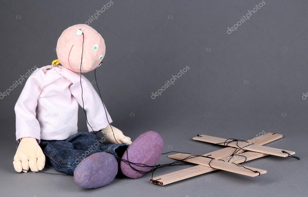 Wooden puppet sitting on grey background — Stock Photo © belchonock ...