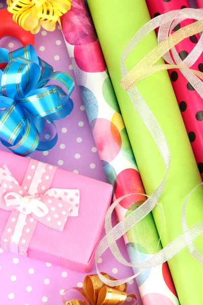 Rolls of Christmas wrapping paper with ribbons, bows on color ...