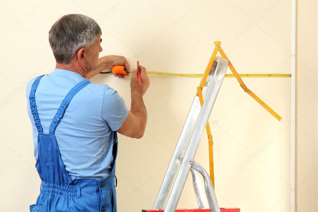 Builder measuring wall in room close-up Stock Photo by ©belchonock 19022665