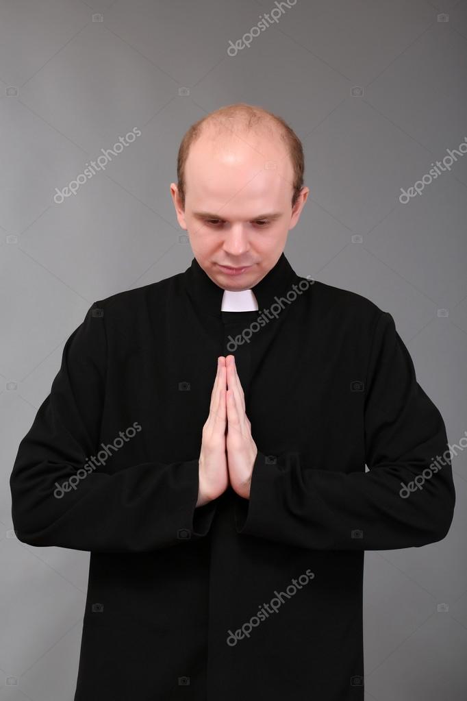 Young priest on gray background Stock Photo by ©belchonock 19504125