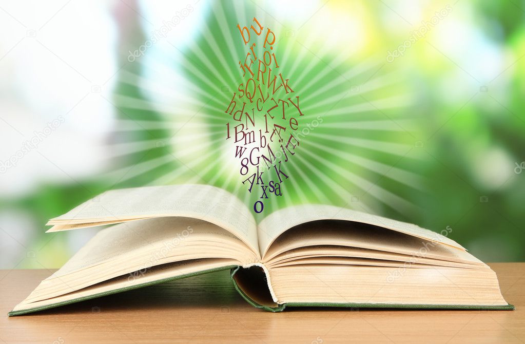 Libro abierto con letras que salen volando sobre fondo brillante 2023