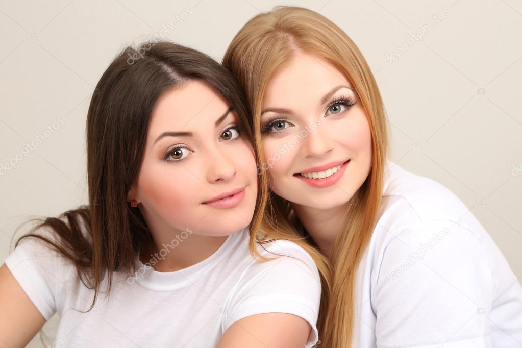 Two girl friends smiling on room Stock Photo by ©belchonock 22188005