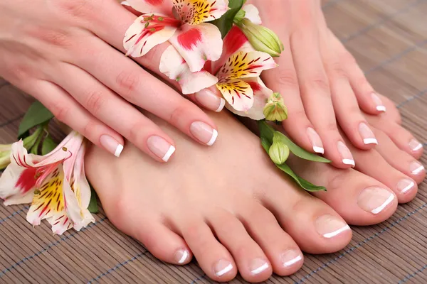 Beautiful woman legs and hands on bamboo mat - Stock Image - Everypixel