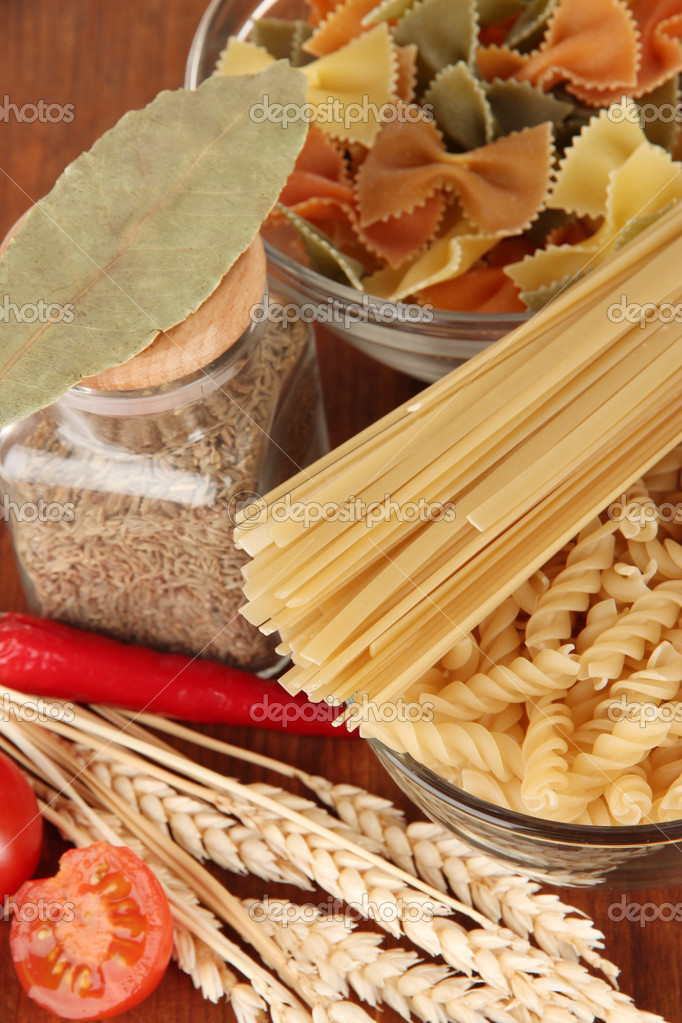 Different types of pasta, spices, tomatoes on a wooden table Stock ...