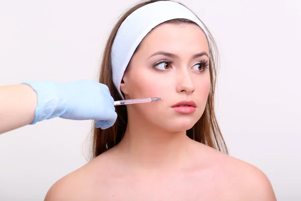 Young woman receiving plastic surgery injection on her face close up ...