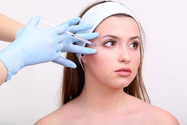 Young woman receiving plastic surgery injection on her face close up ...