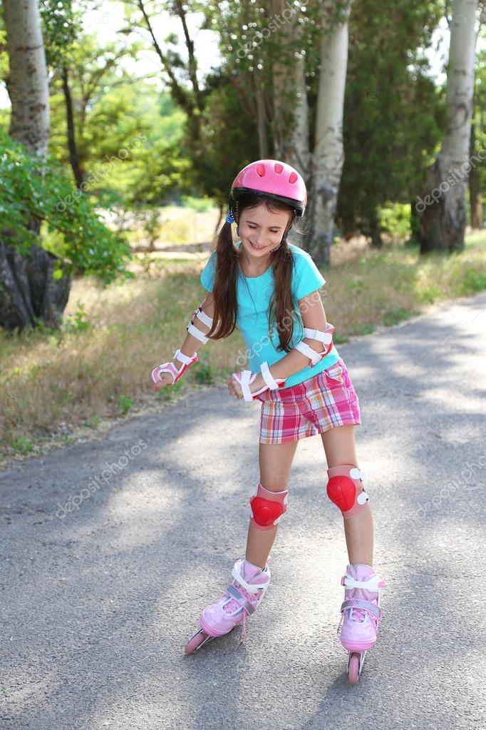 Little girl in roller skates at park Stock Photo by ©belchonock 25906563