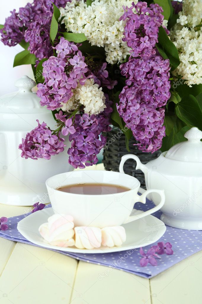 Composition with beautiful lilac flowers, tea service on wooden table ...