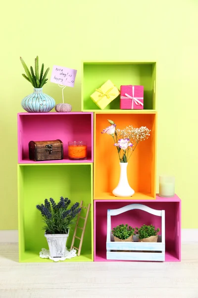 Shelves of different bright colors with decorative addition on wall ...
